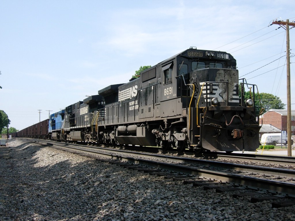 A beat up dash-8 shoves empty Herzog train into a rock quarry across the state line
